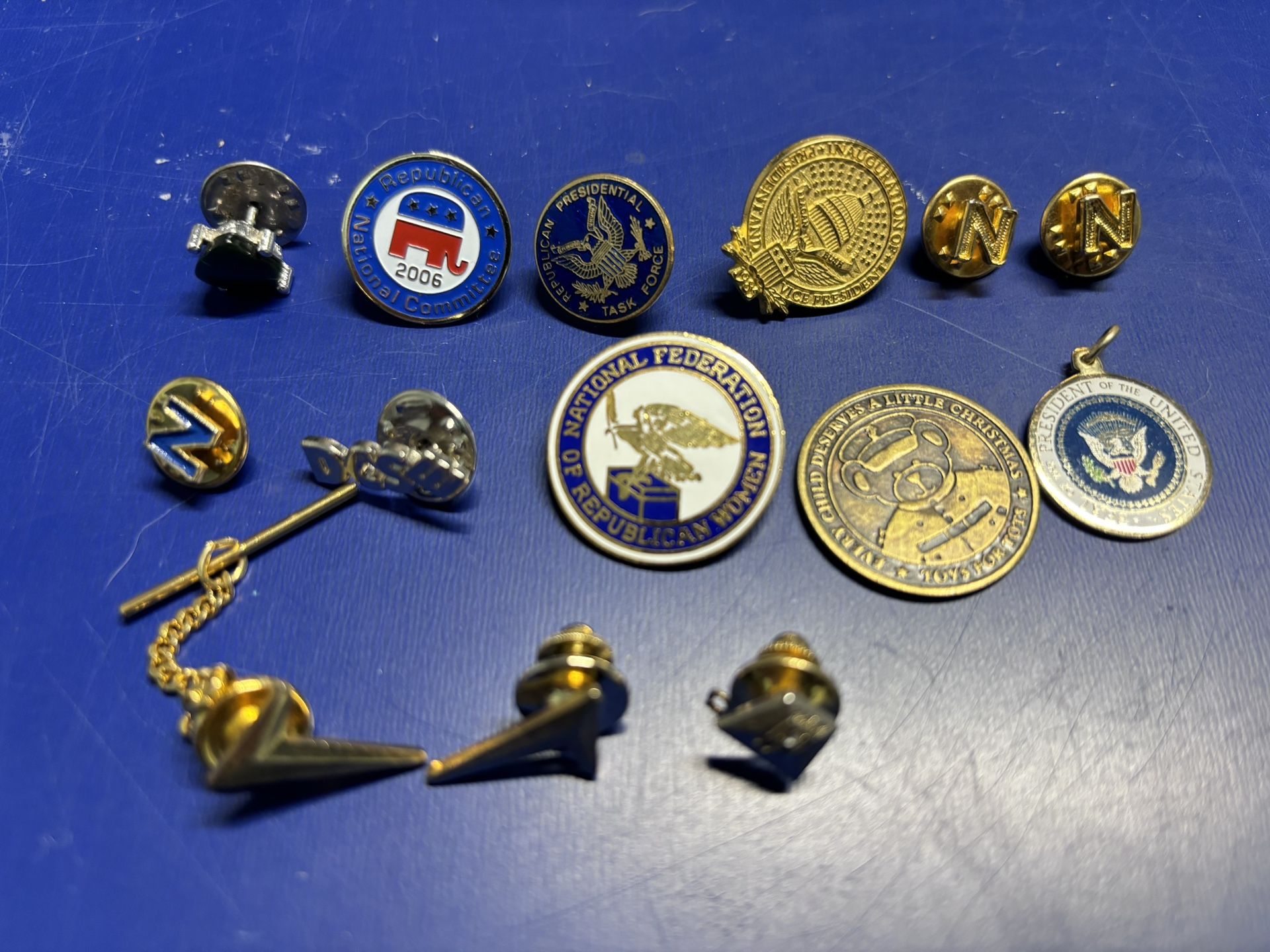 Lot of lapel pins plus a token and a pendent. Mid 80s to mid 2000s. Lot ...